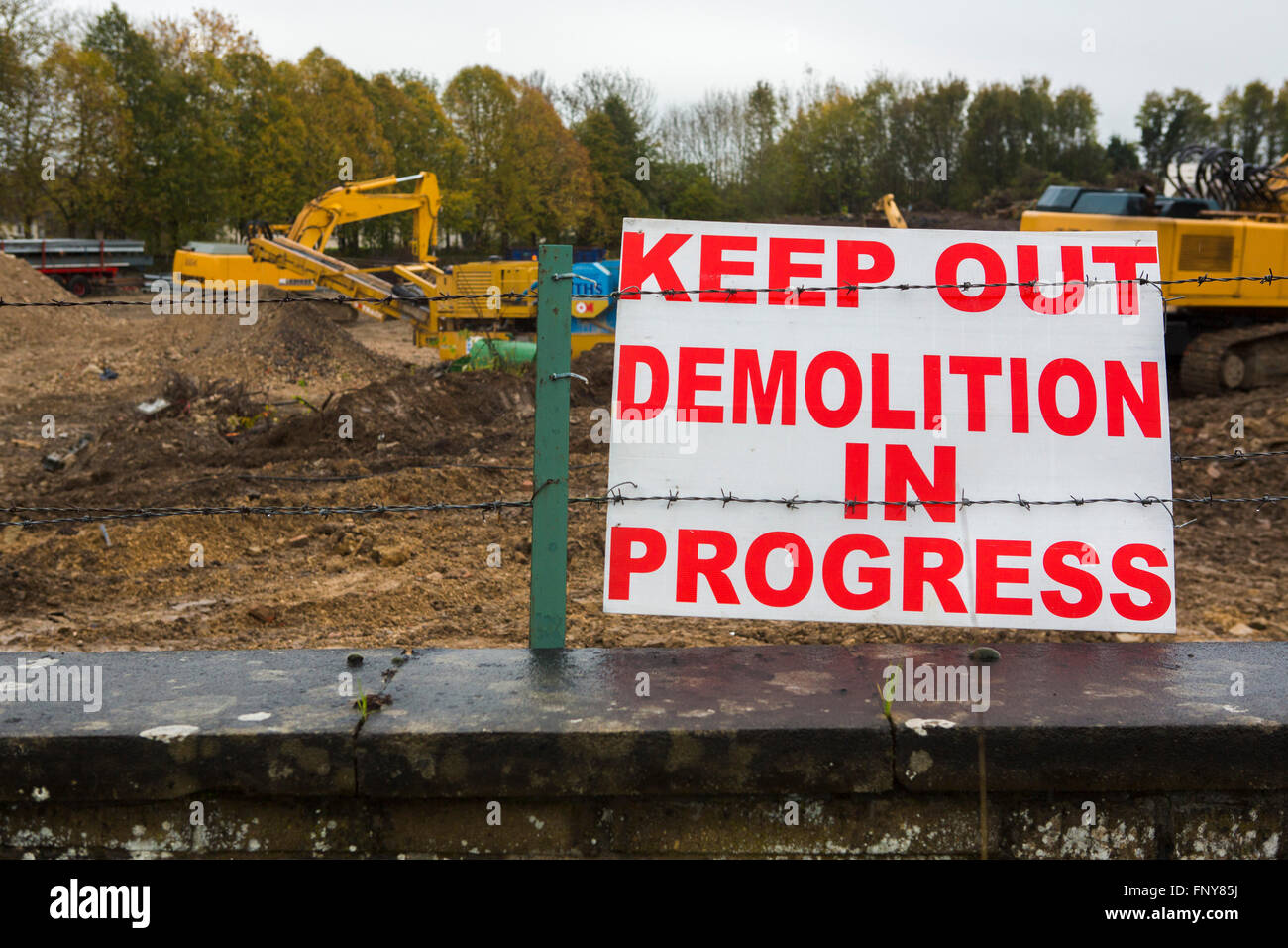 A red painted warning sign on a fence outside a demolition site Stock ...