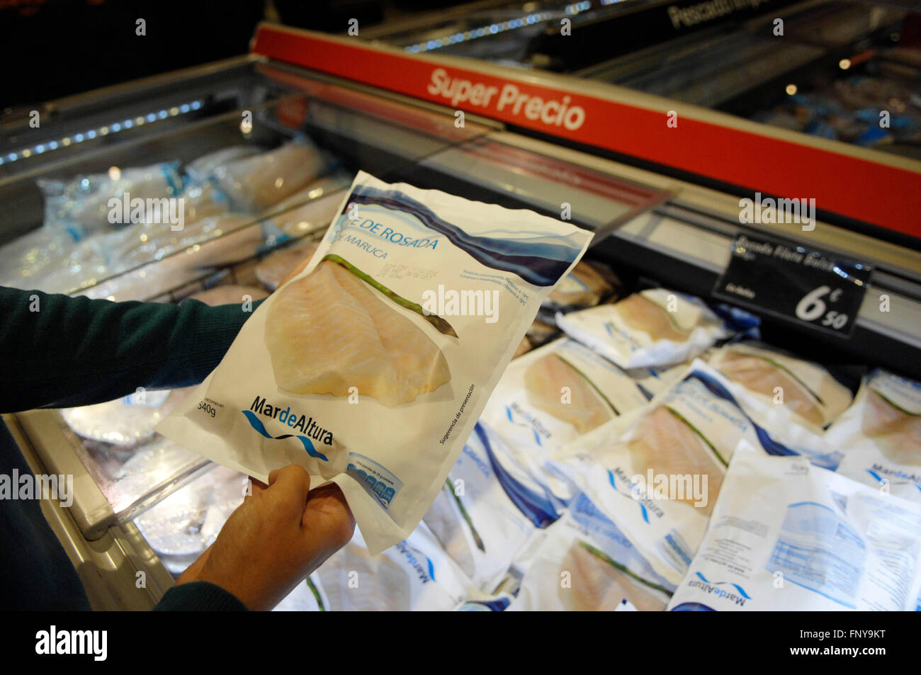 Frozen Fish Packet being handled by customer in the frozen food section ...