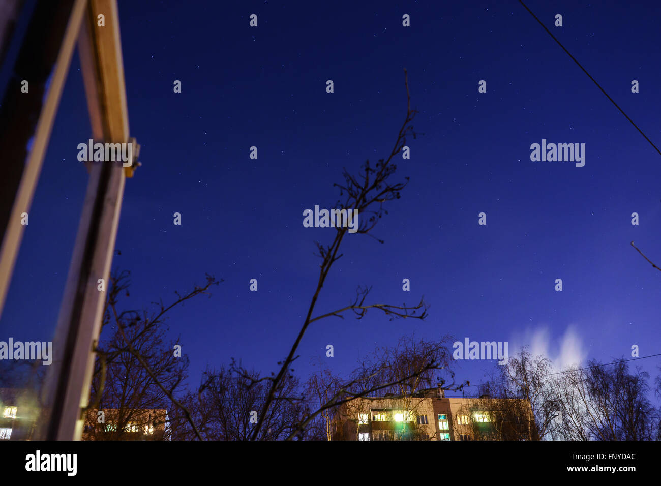 The starry sky and the moon over the buildings. View from my window ...