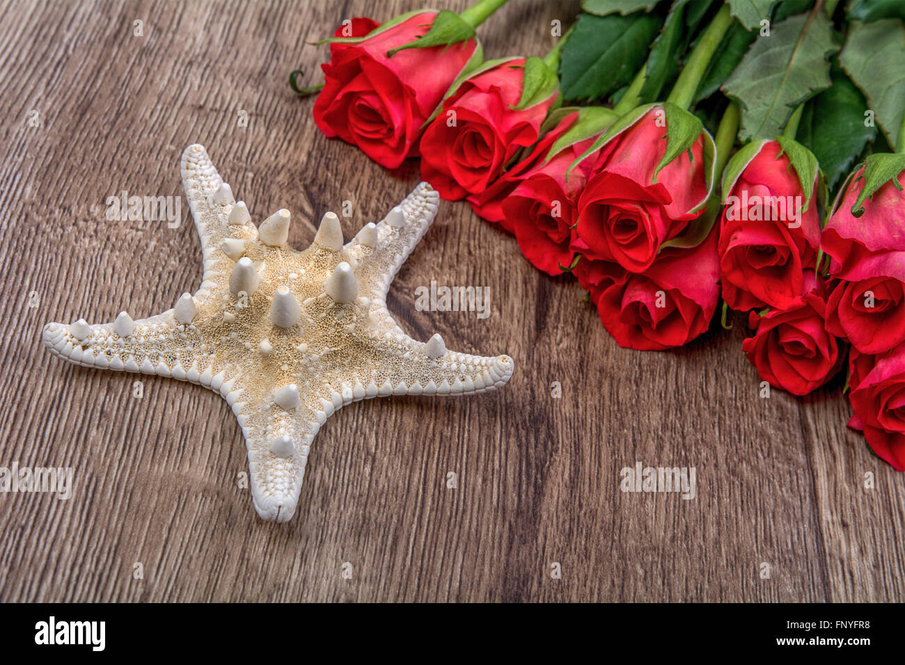 White starfish and red roses on a wooden background Stock Photo - Alamy