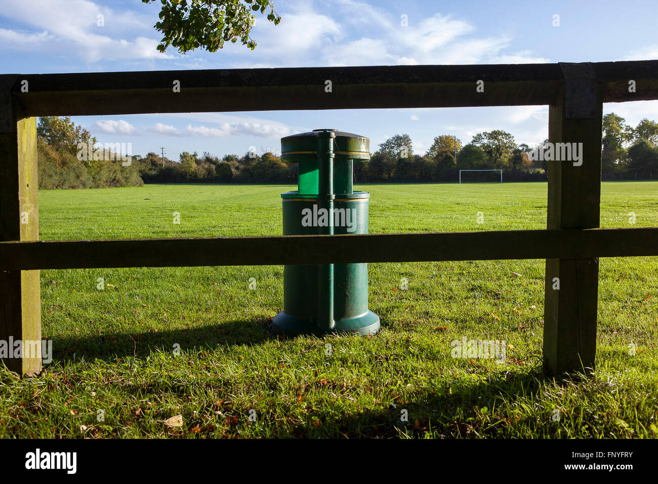 A local playing field in a village with goal posts and waste bin in the ...
