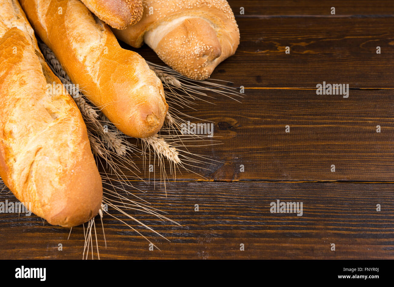 Close up of Artisan bread loaves on top of dried whole wheat stalks ...