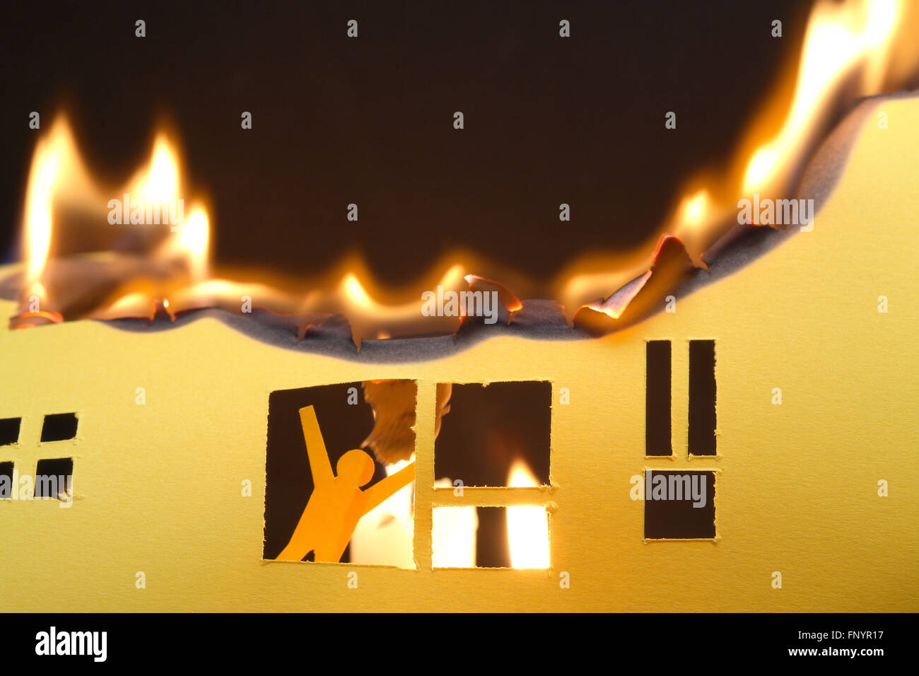 Paper man in window of burning house on dark background Stock Photo - Alamy