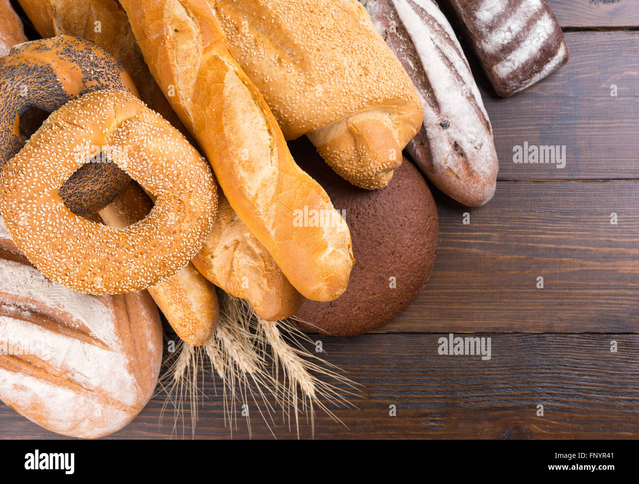 Close up of various types of whole baked bread loaves on mahogany ...