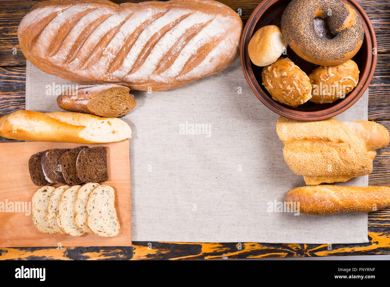 Still life of a large assortment of fresh loaves of bread sliced and ...