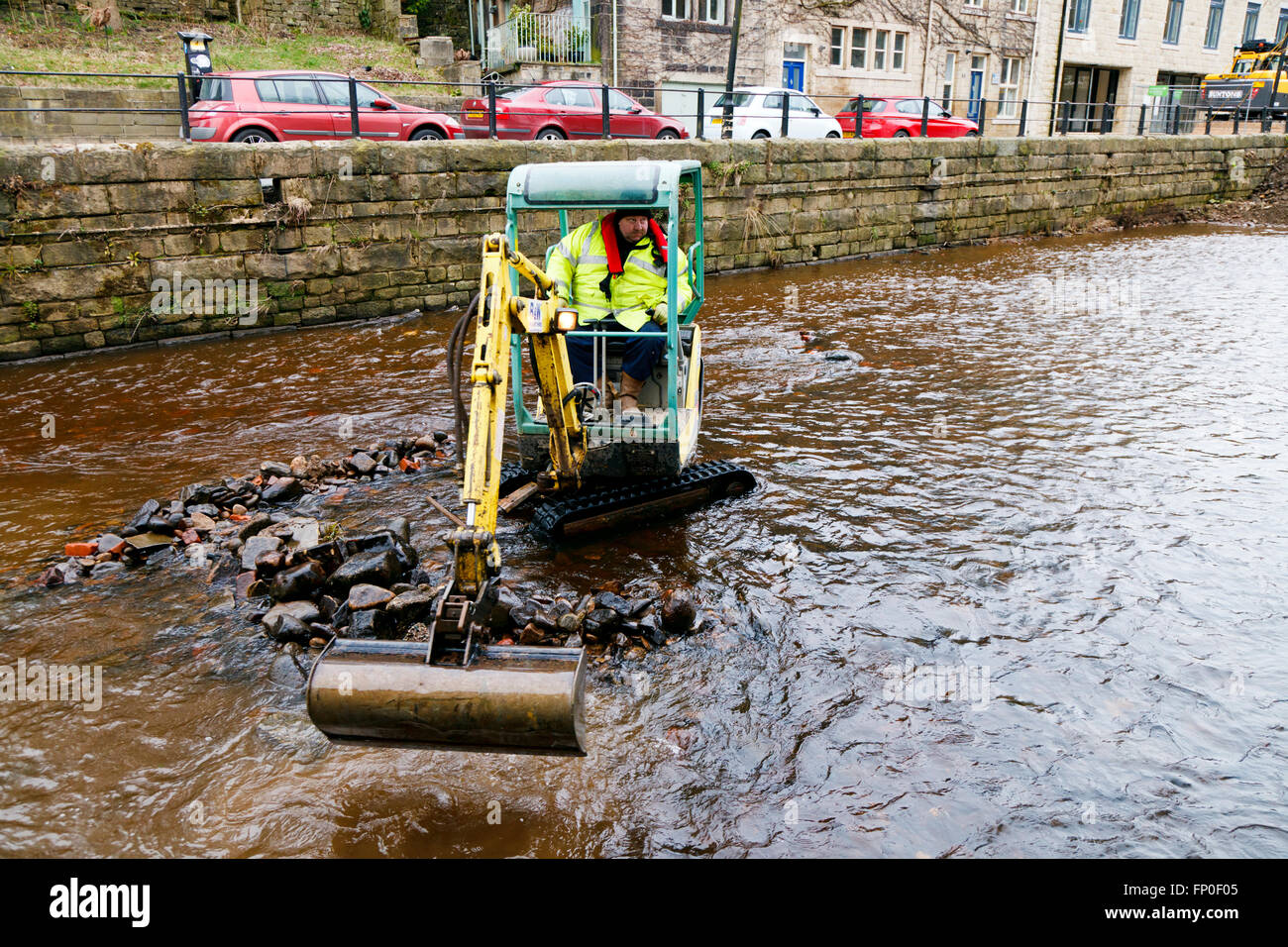 Hebden Bridge, Yorkshire, UK. 15th Mar, 2016. A digger gathers up ...
