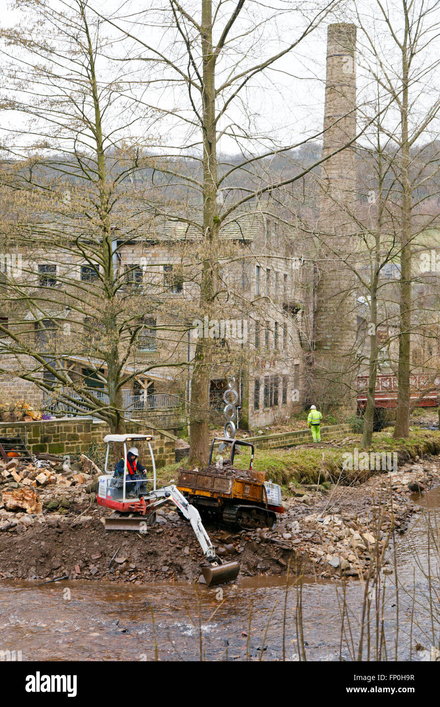 A small rubber track carrier being loaded with rubble dredged out of ...