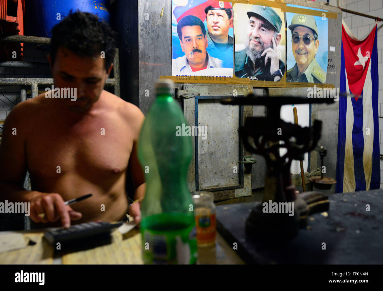 Havana, Cuba. 16th Mar, 2016. A man works in his shop, decorated with ...