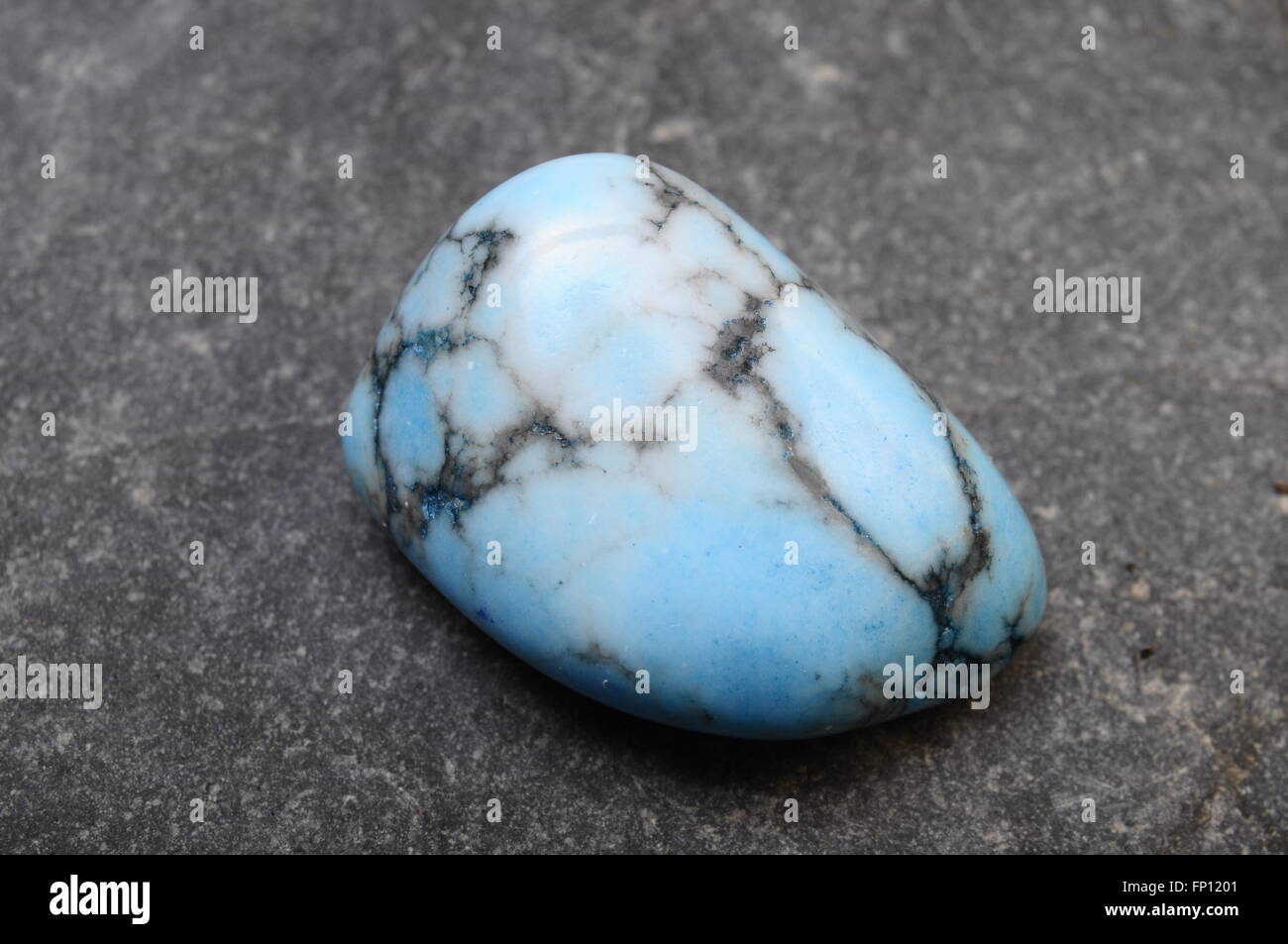Close up of a blue and black turquoise stone on mineral background ...