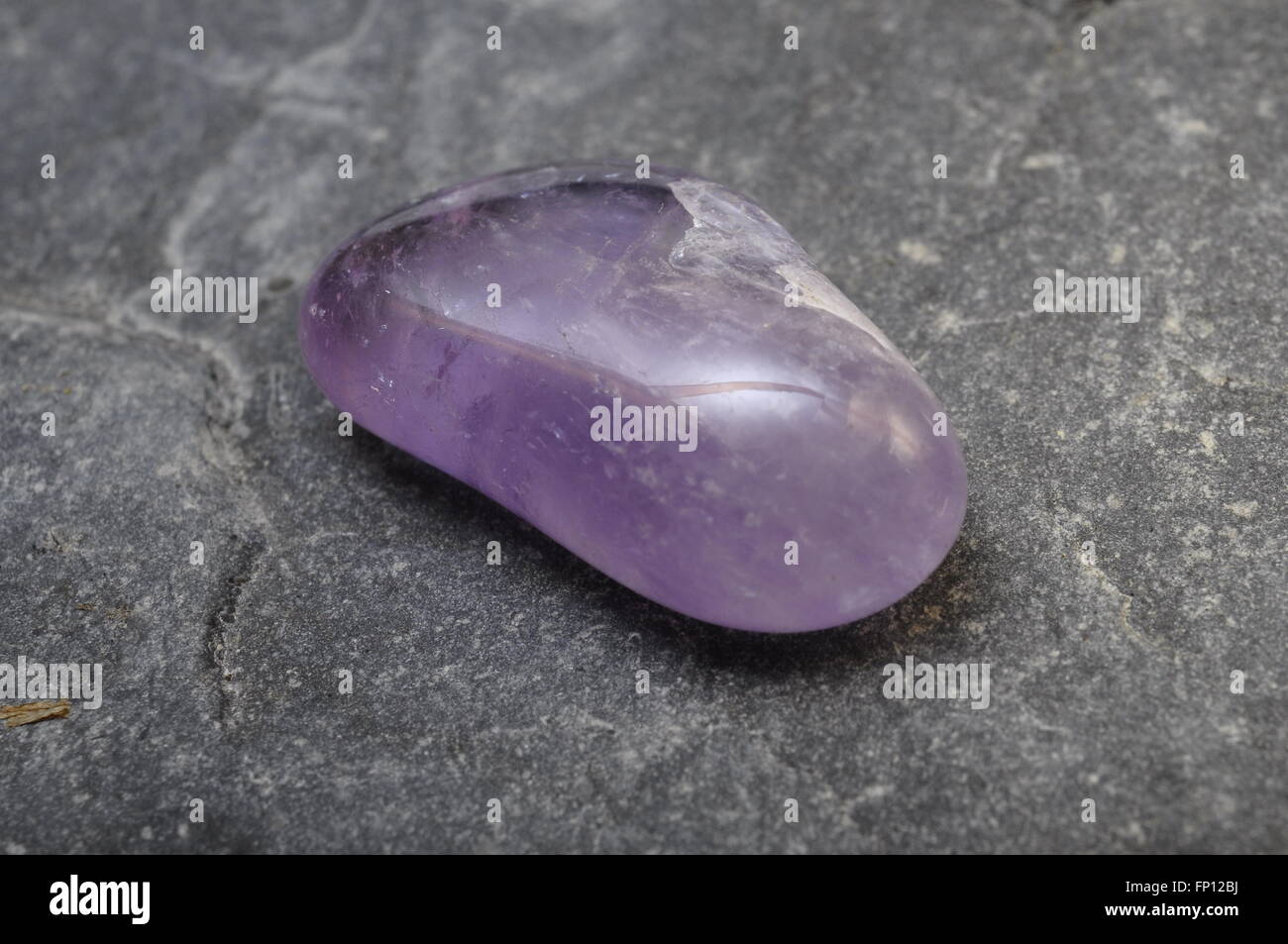 Close up of a purple amethyst stone on mineral background Stock Photo ...
