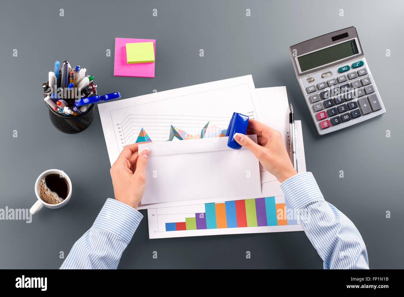 Lady sealing envelope with stapler. Secretary's hand using stapler. It ...