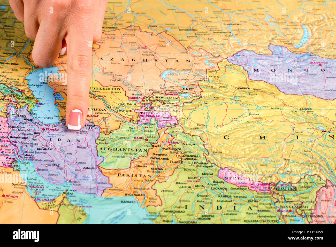 Lady's finger points at Iran. Woman showing Iran on map. At the ...