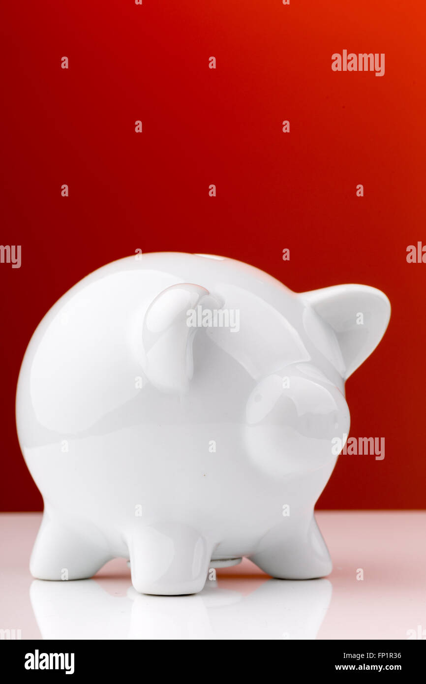White piggy bank on red background Stock Photo - Alamy