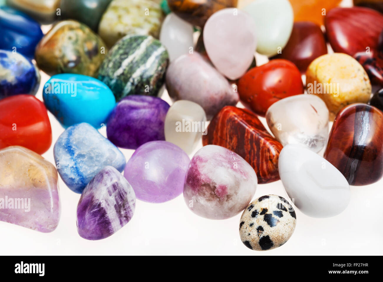 many tumbled natural mineral gem stones close up on white background ...