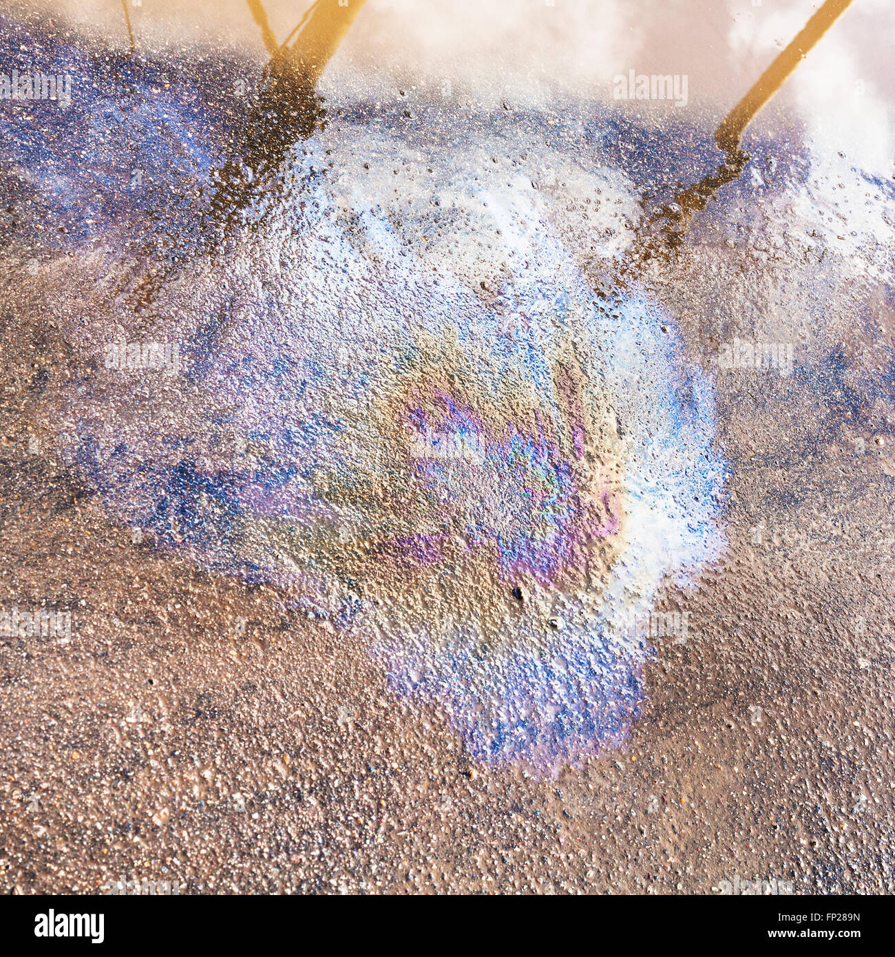 rainbow stain of motor oil on wet asphalt pavement in city Stock Photo ...