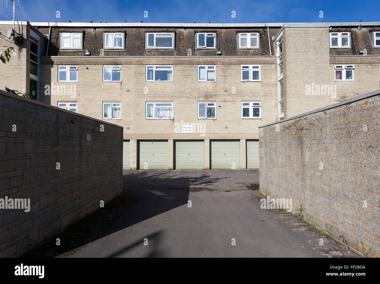 Town centre flats with garages under the building with bright sunshine ...