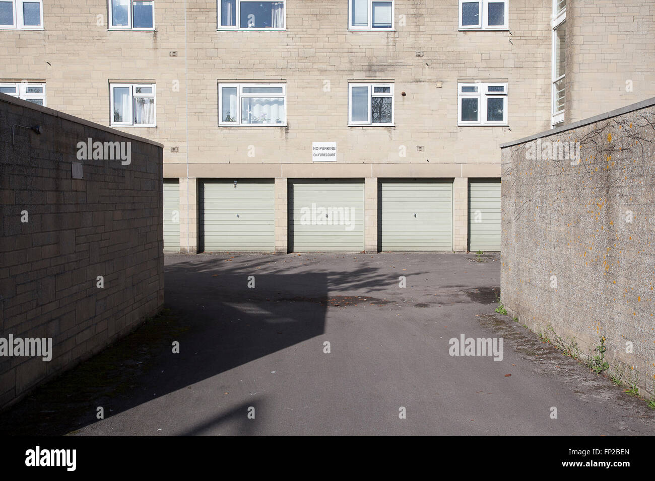 Town centre flats with garages under the building with bright sunshine ...