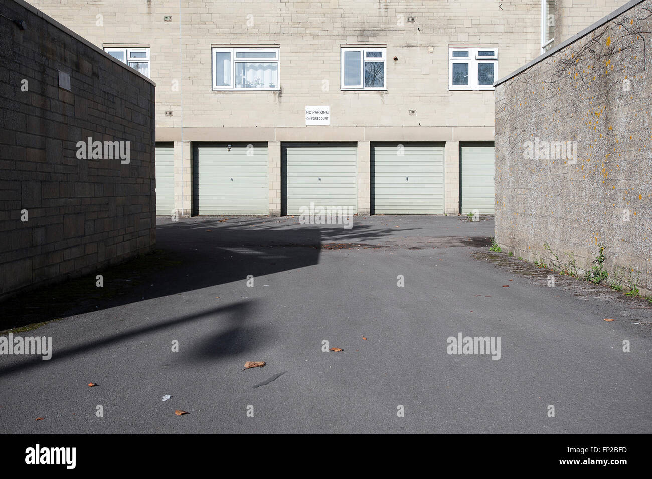 Town centre flats with garages under the building with bright sunshine ...