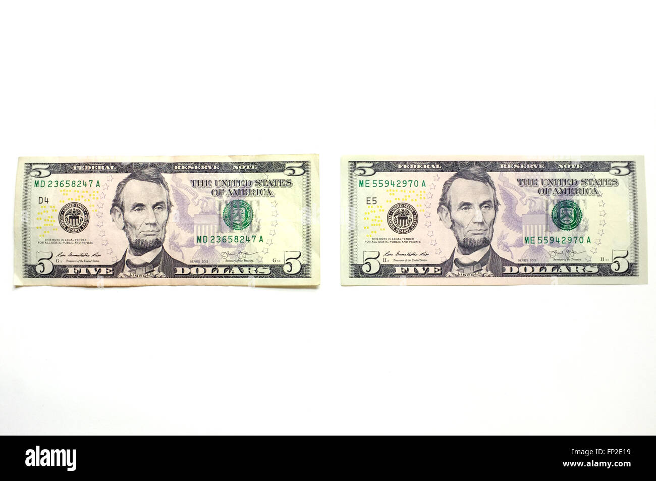 American Five Dollar notes photographed against a white background ...