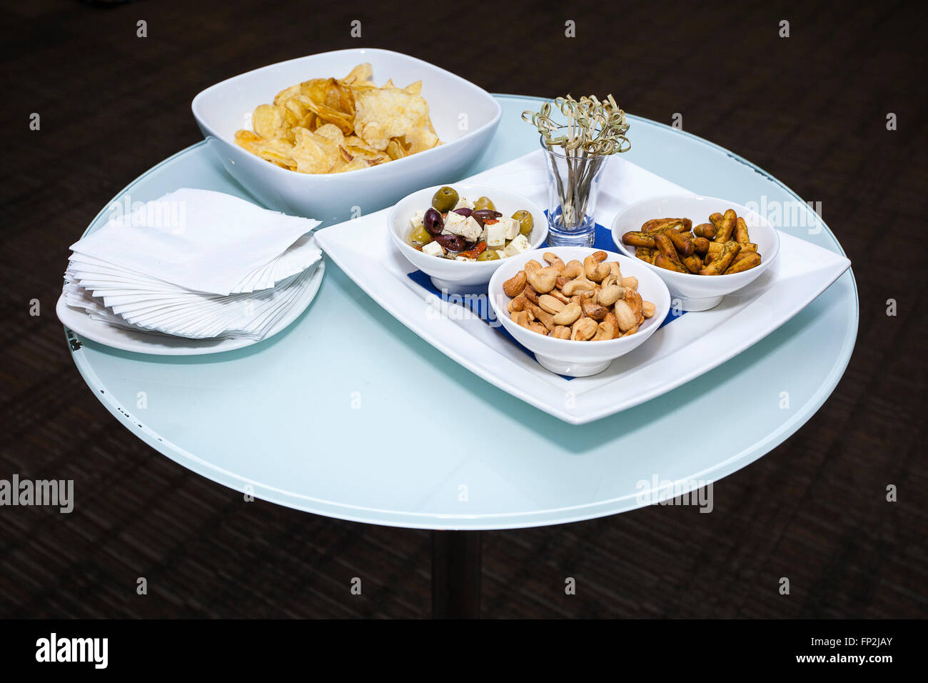 A table of nibbles, canapes etc. including nuts, crisps and olives at a ...