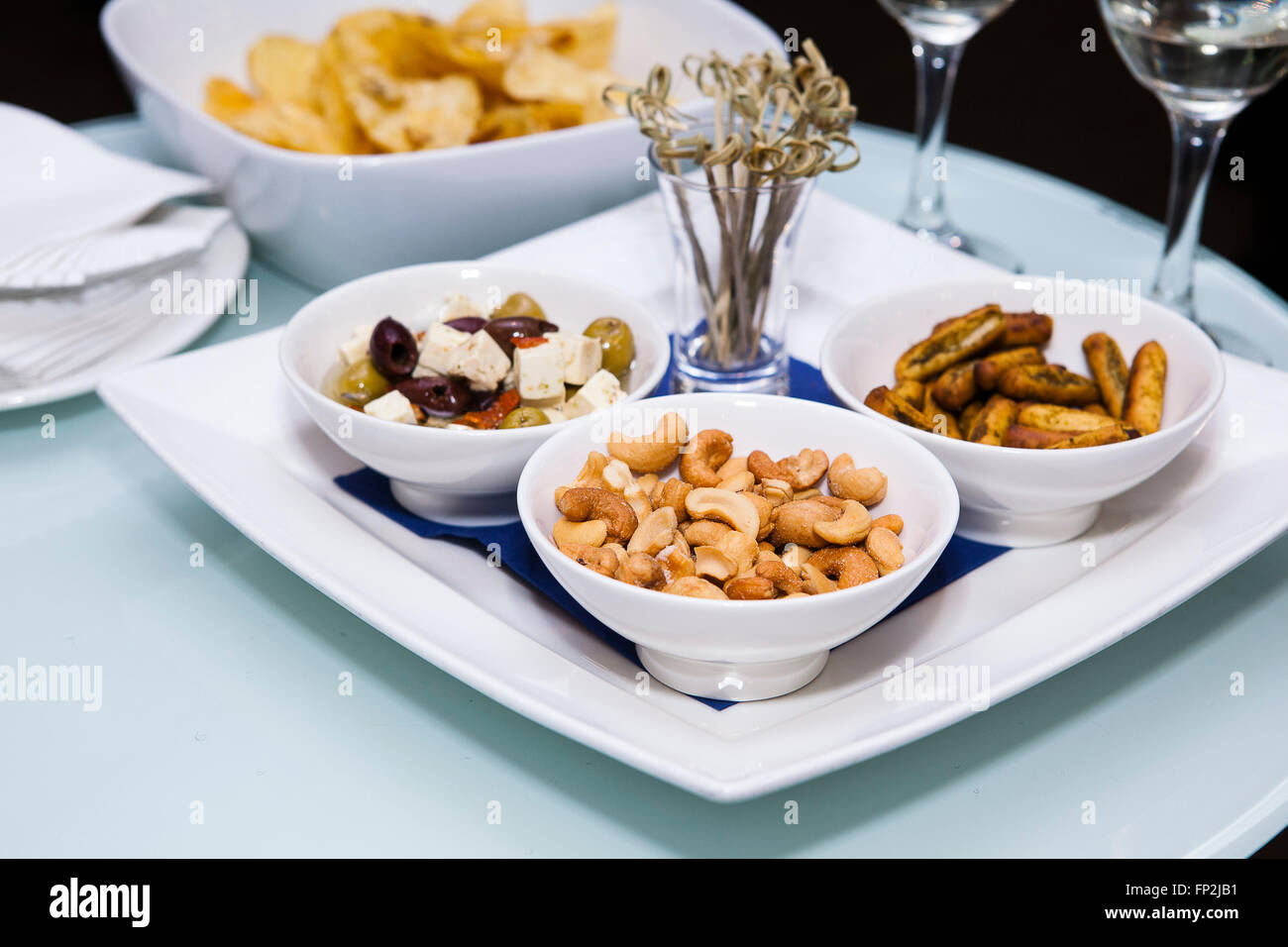 A table of nibbles, canapes etc. including nuts, crisps and olives at a ...