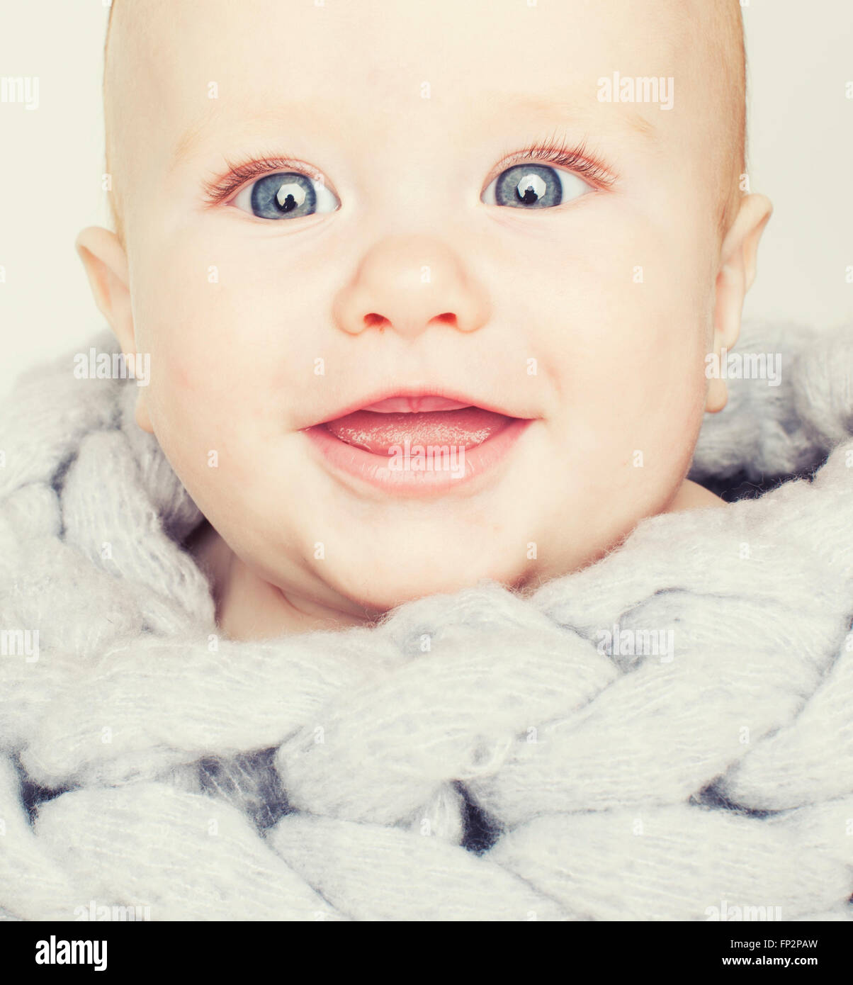 little cute red head baby in scarf all over him close up isolated ...