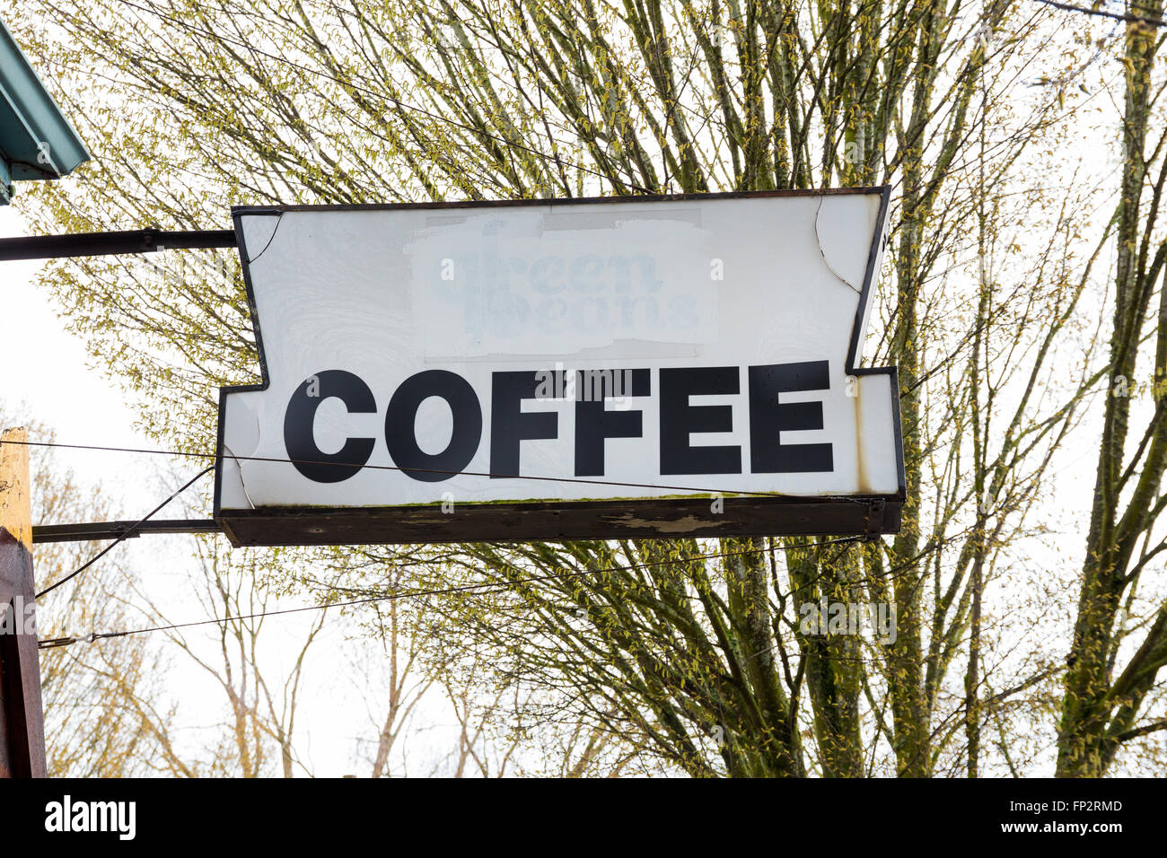 Attached to a cafe building is a very generic coffee sign with white ...