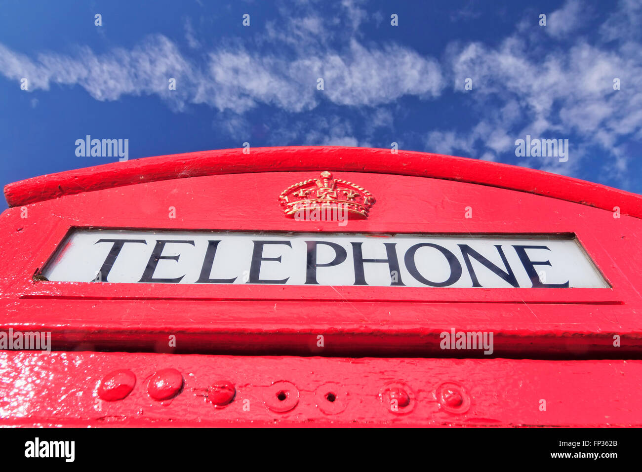 Red English telephone booth against blue sky, England, United Kingdom ...
