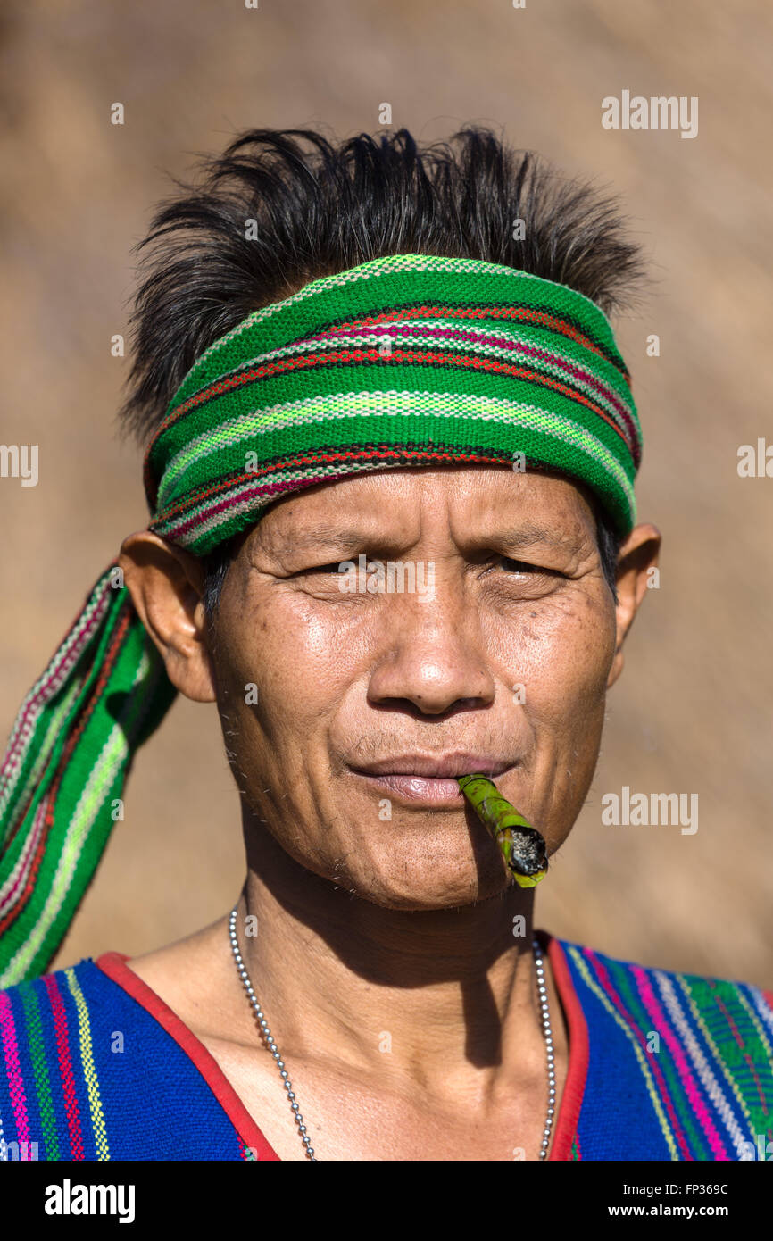 Man in traditional costume smoking cigar, Phnong tribe, ethnic minority ...