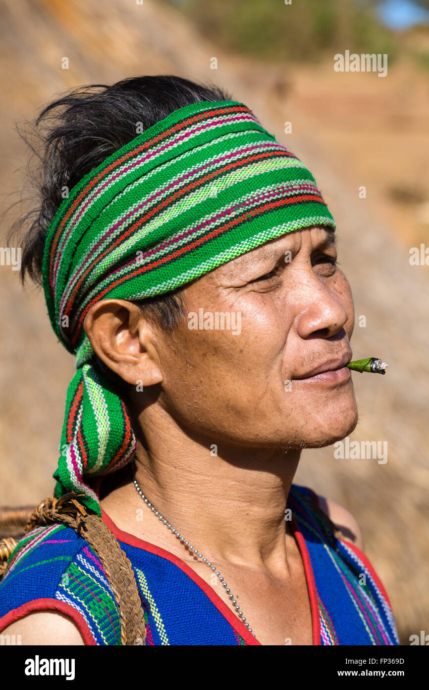 Man in traditional costume smoking cigar, Phnong tribe, ethnic minority ...