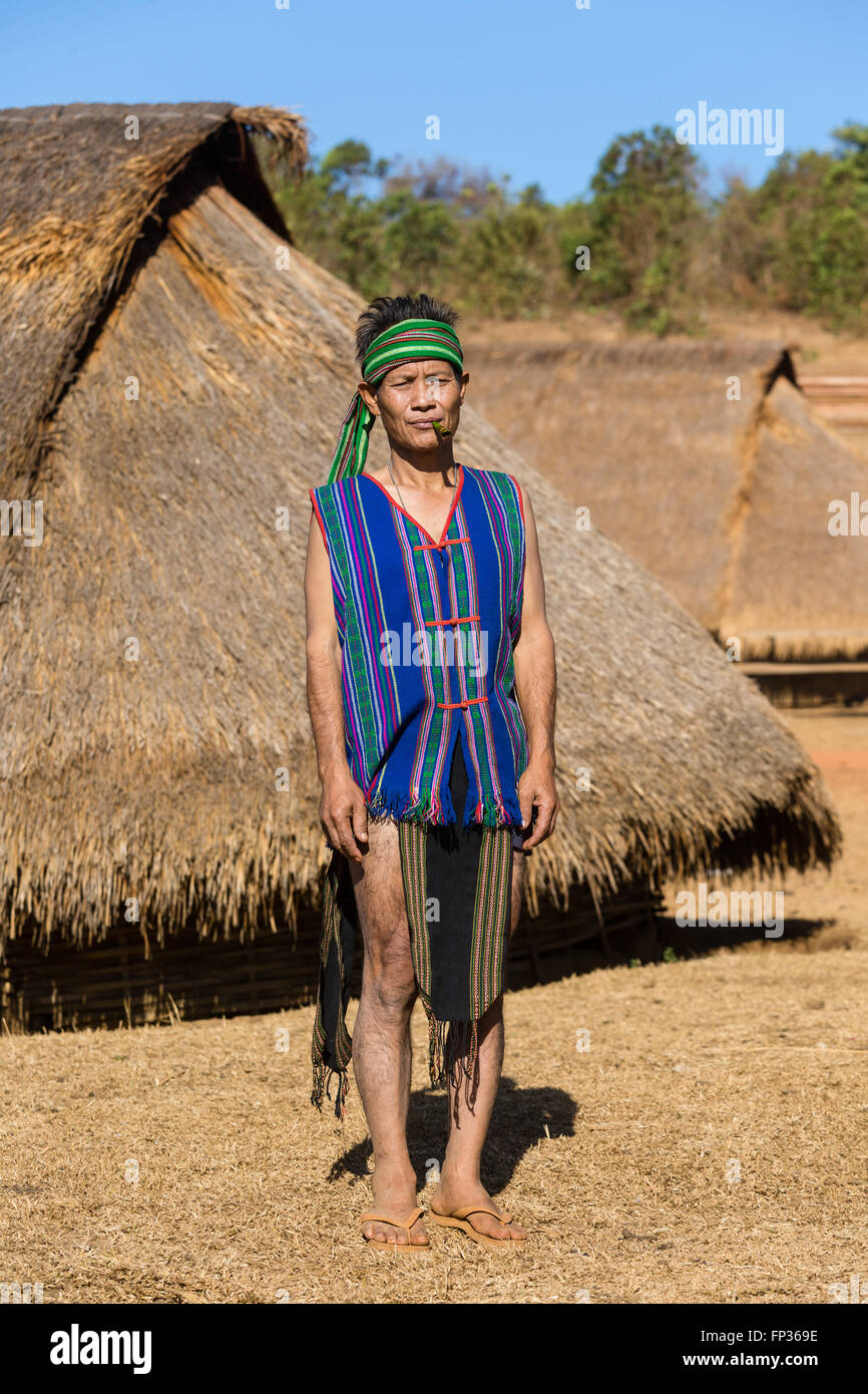 Man in traditional costume in front of a Phnong house, Ethnic minority ...