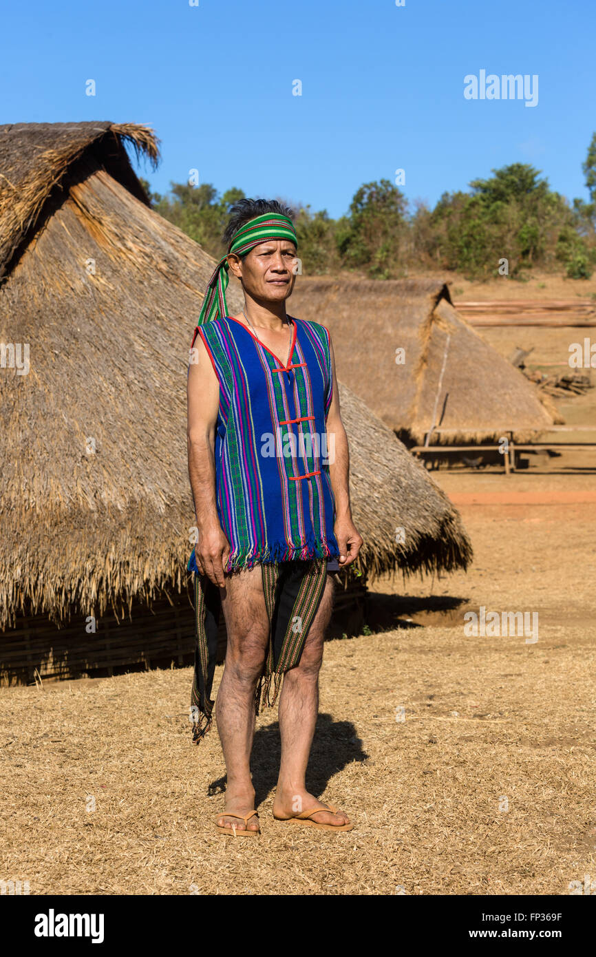 Man in traditional costume in front of a Phnong house, Ethnic minority ...