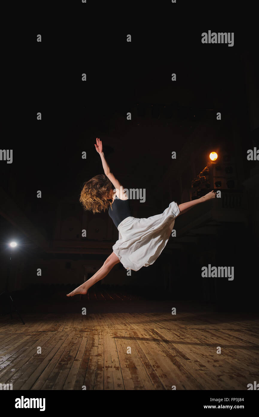 Photo of young brunette dancer girl, ballerina in white skirt in split ...