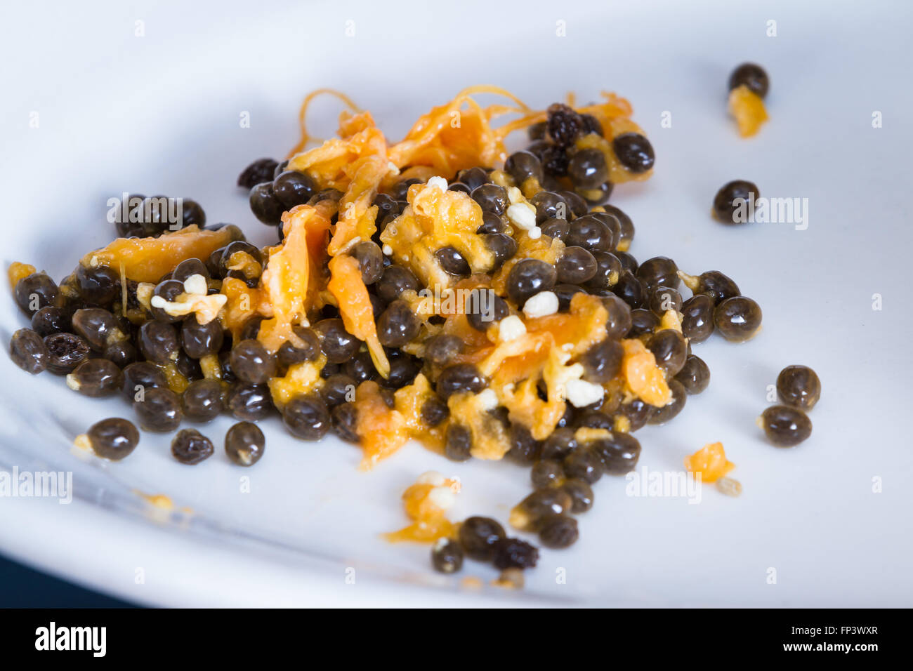 papaya seeds on a plate with a slimy texture and shine Stock Photo - Alamy