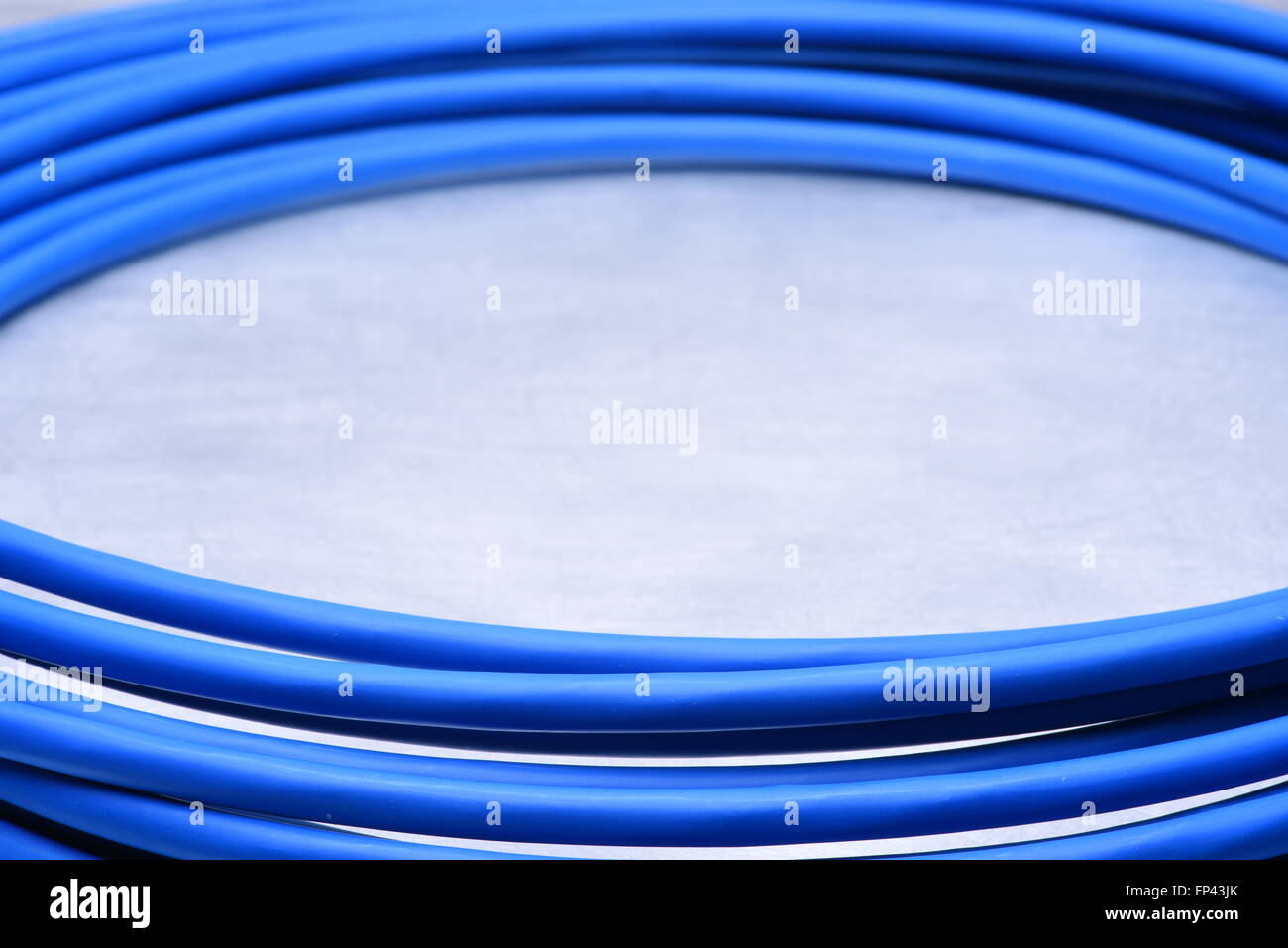Blue cable on grey background Stock Photo - Alamy