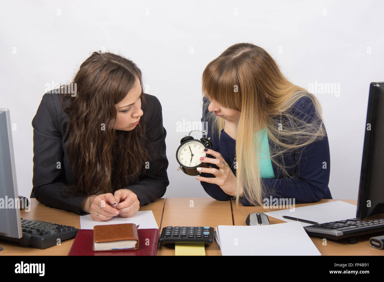 Two office workers at the end of the day looking at his watch Stock ...
