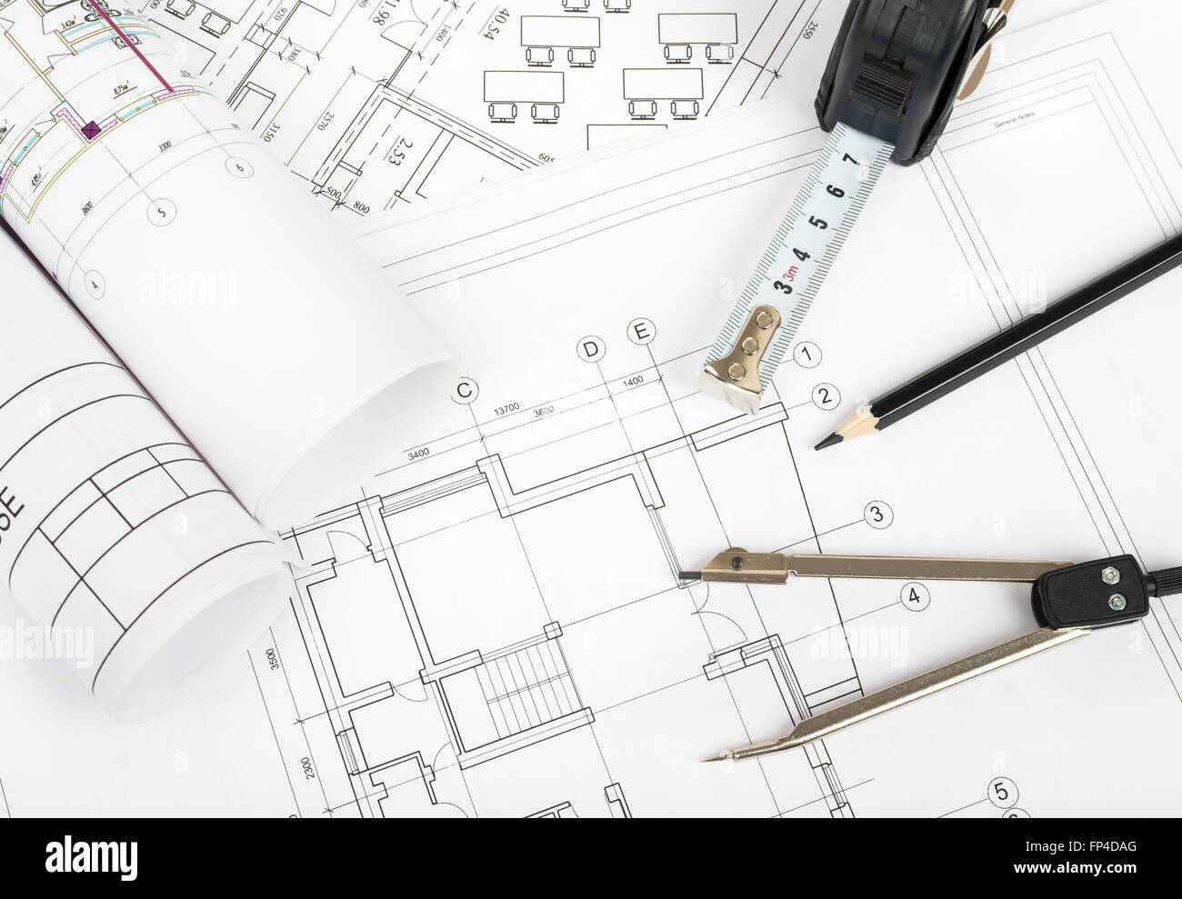 Architecture plan and rolls of blueprints with meter and divider ...