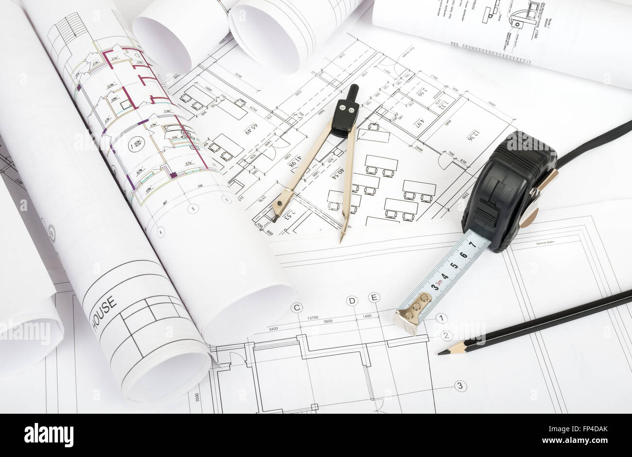 Architecture plan and rolls of blueprints with meter and divider ...
