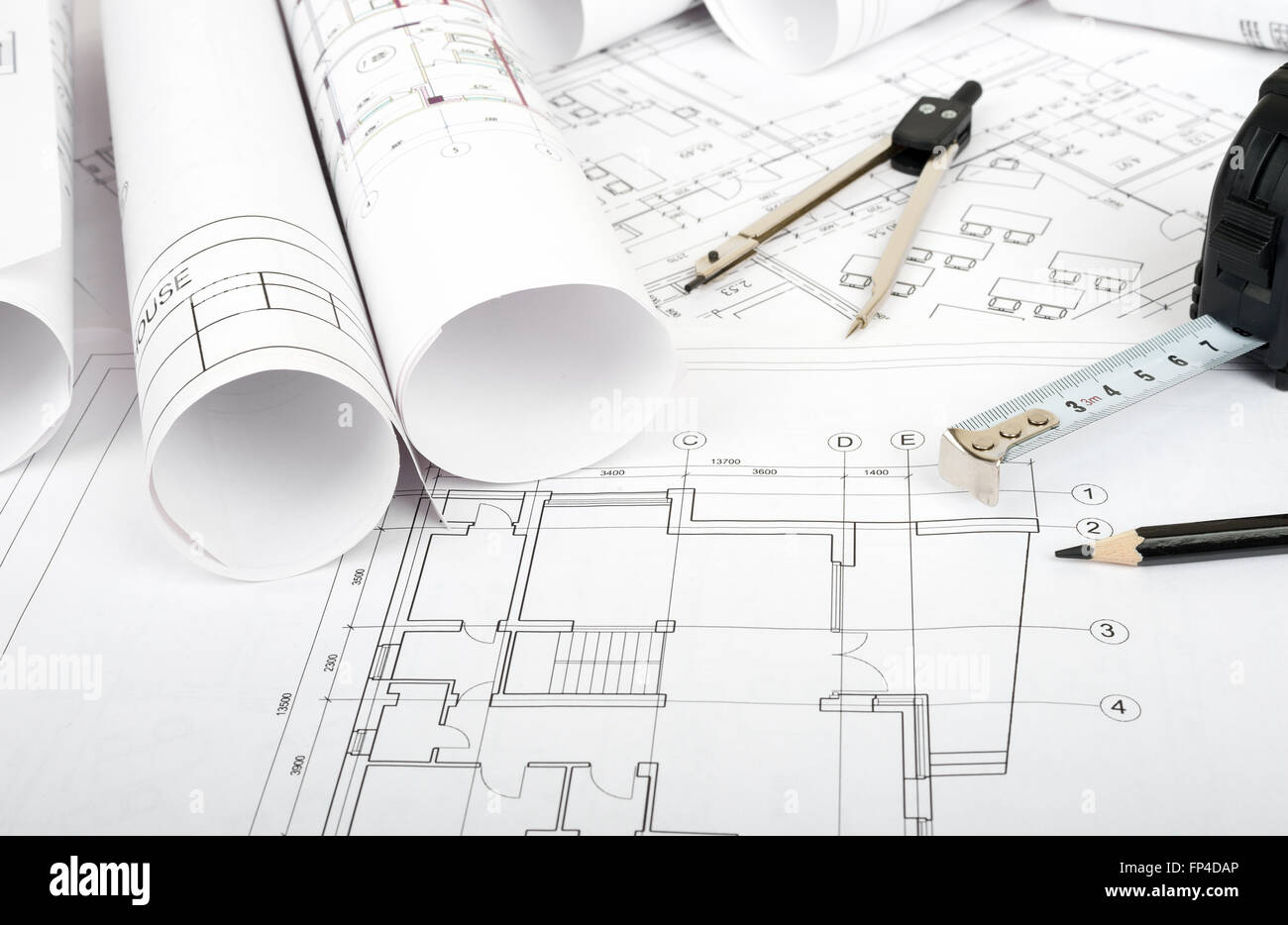 Architecture plan and rolls of blueprints with meter and divider ...