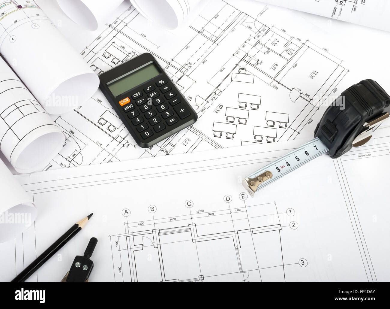 Architecture plan and rolls of blueprints with meter and calculator ...