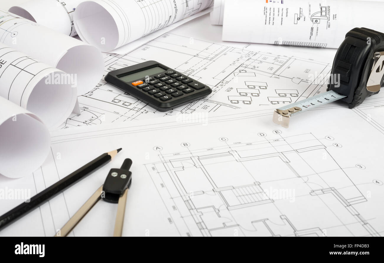Architecture plan and rolls of blueprints with meter and calculator ...