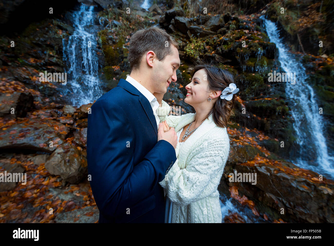 Lovely wedding couple softly holding hands and lovingly look at each ...