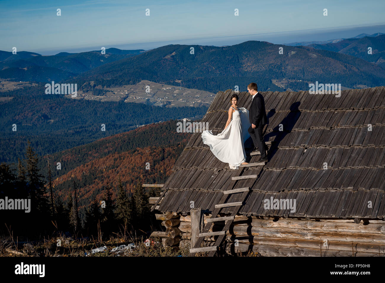 Happy bride and groom on the roof of country house. Breathtaking ...