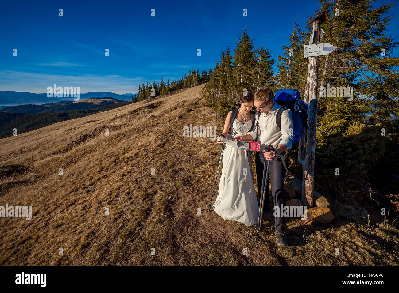 Wedding tourist couple with map coming up to the mountain Stock Photo ...