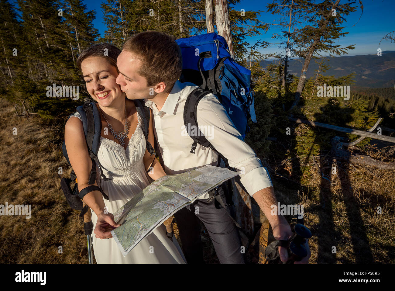 Wedding tourist couple kissing with map in hands. Honeymoon at the ...