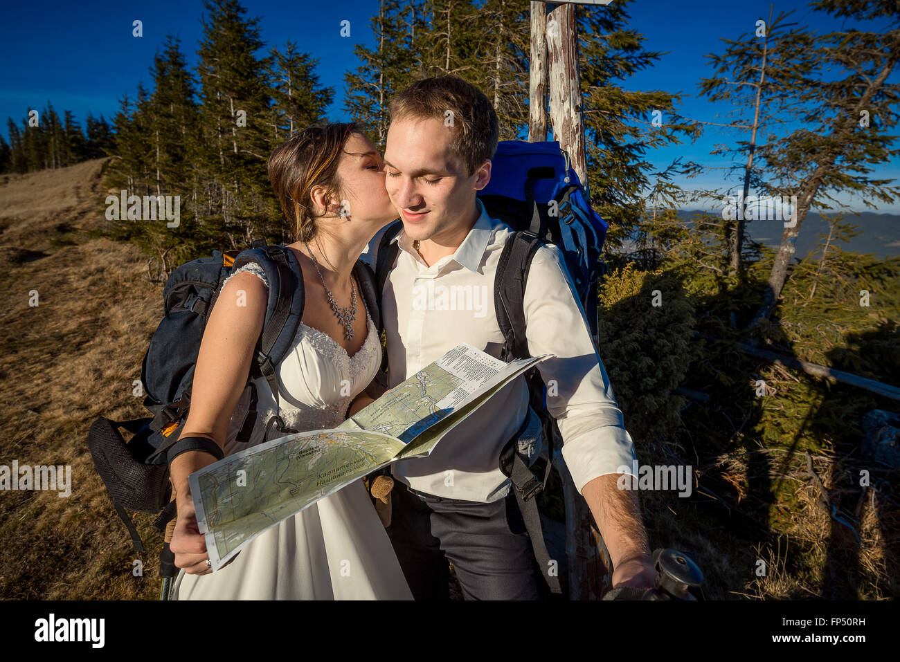 Wedding tourist couple kissing with map in hands. Honeymoon at the ...
