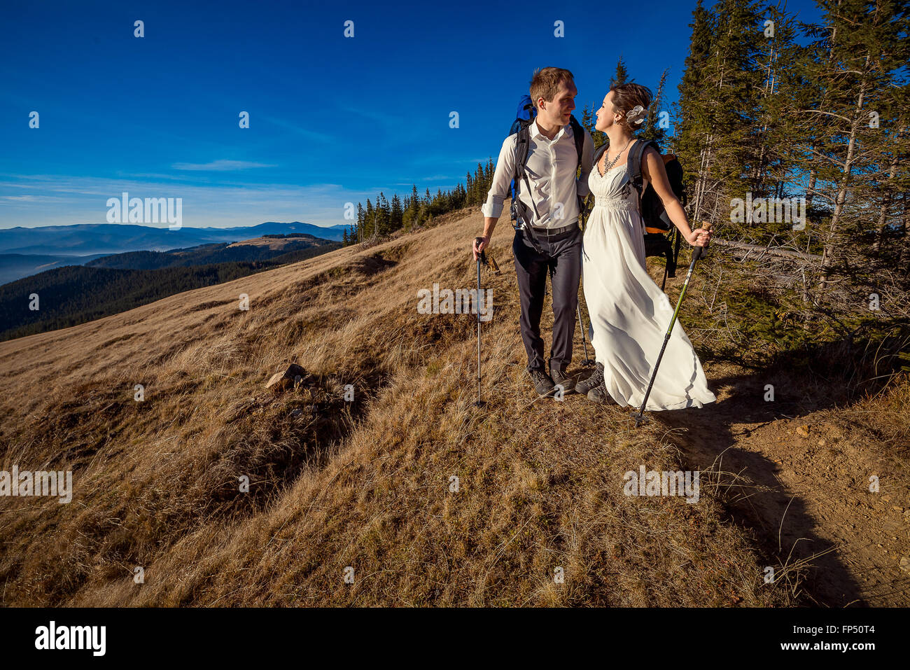 Tourist wedding couple climbs on the top of mountain. Honeymoon Stock ...