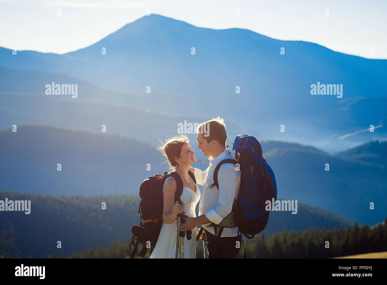 Beautiful tourist wedding couple hugs on the top of mountain. Wonderful ...