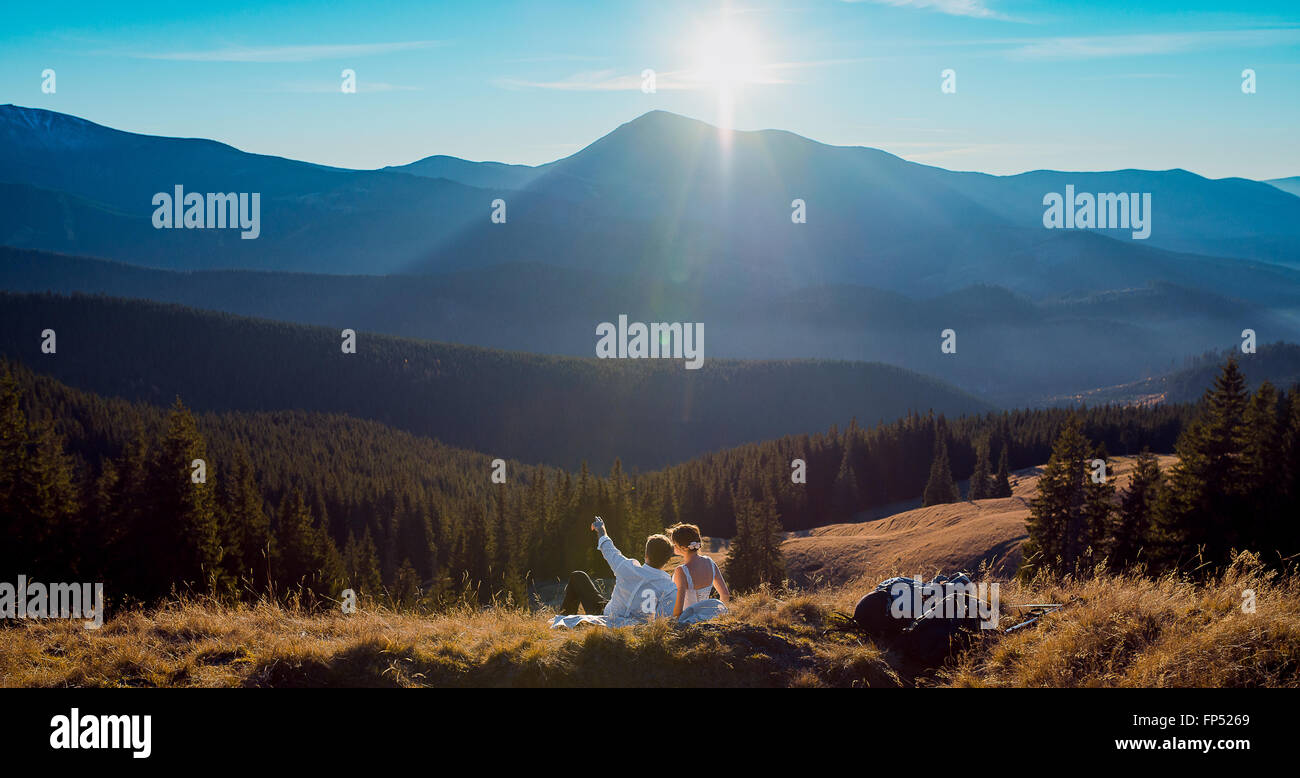 Romantic wedding couple lying on the grass in mountains Stock Photo - Alamy