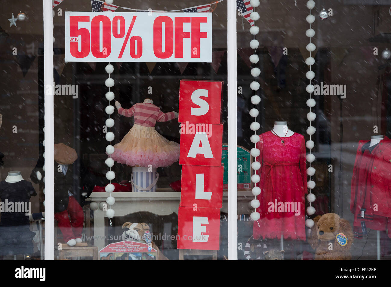 A small shop front with posters advertsiing massive discounts on goods ...